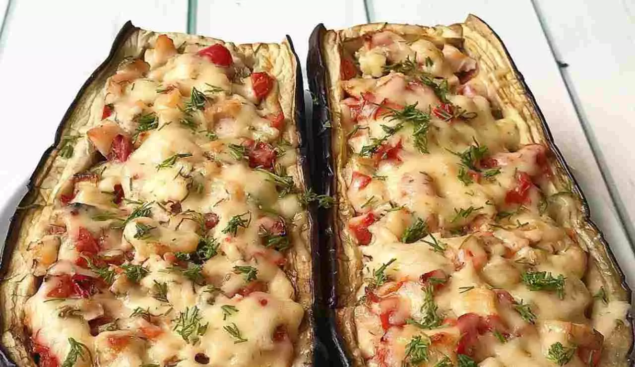 Eggplant stuffed with rice, salmon, cherry tomatoes and emmental
