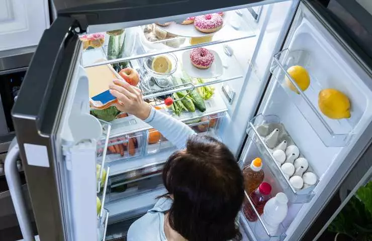 אישה אוספת אוכל מהמקרר