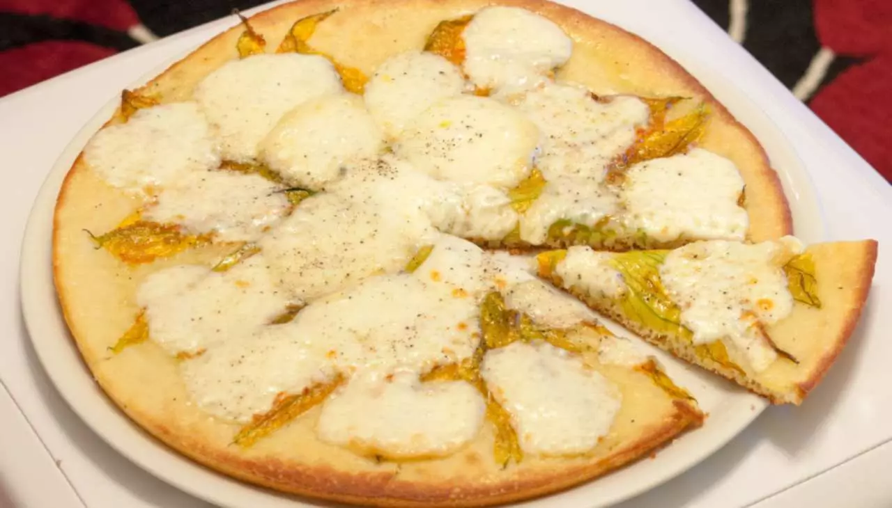 Pizza yomenya ndi maluwa a courgette | Zosavuta komanso zokongoletsedwa ndi mozzarella