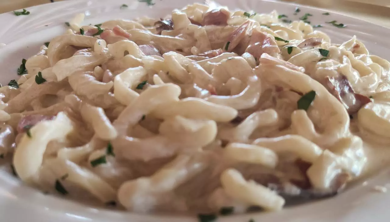 Primer plato de pasta cremosa con queso y tocino